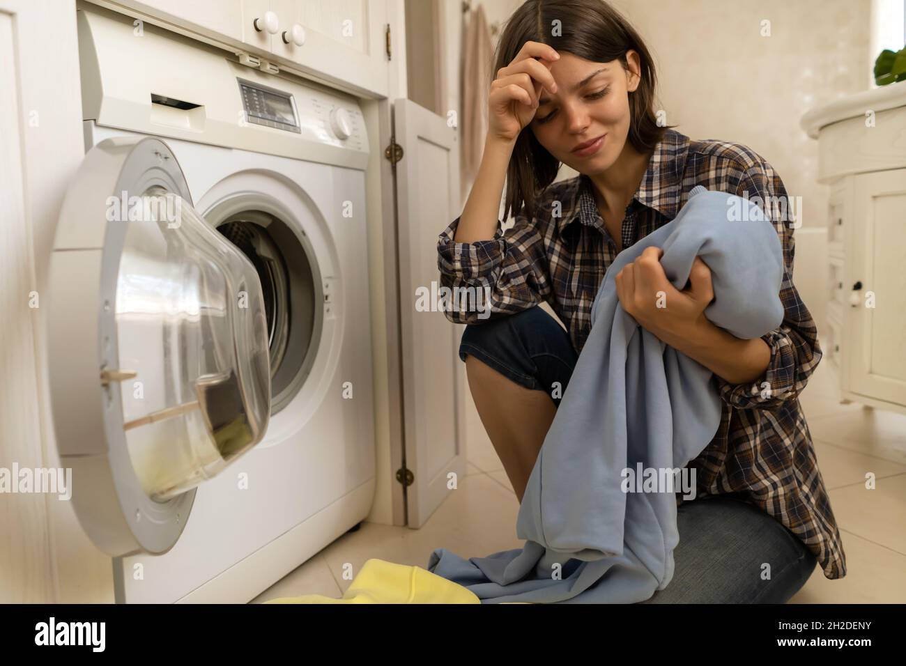 Girl puts clothes in washing mashine Stock Photo - Alamy