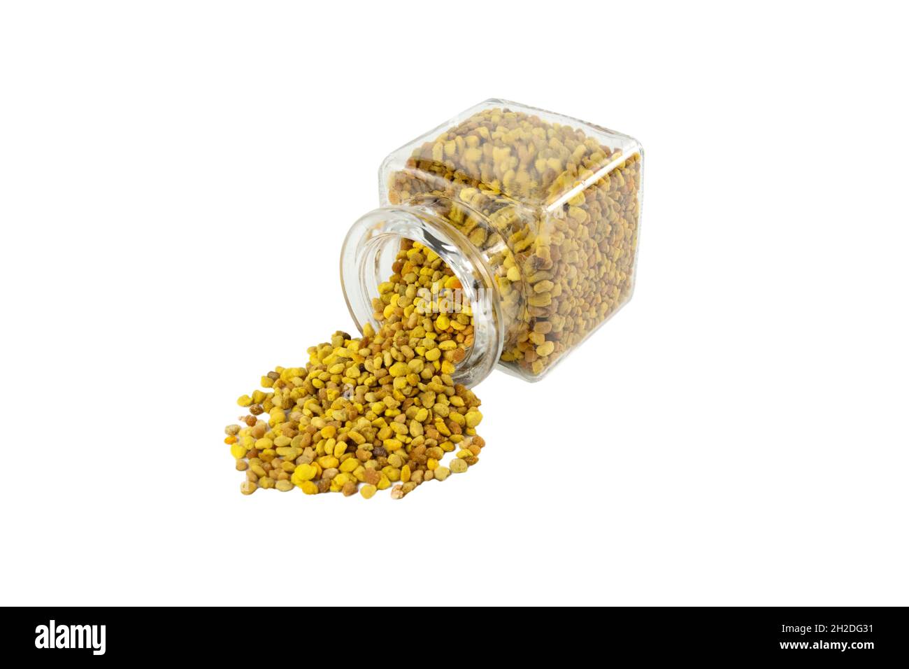 Bee pollen pouring out of the glass jar isolated on white background ...