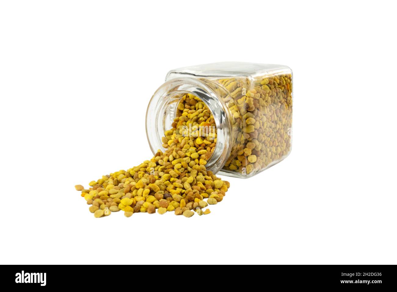 Bee pollen pouring out of the glass jar isolated on white background ...
