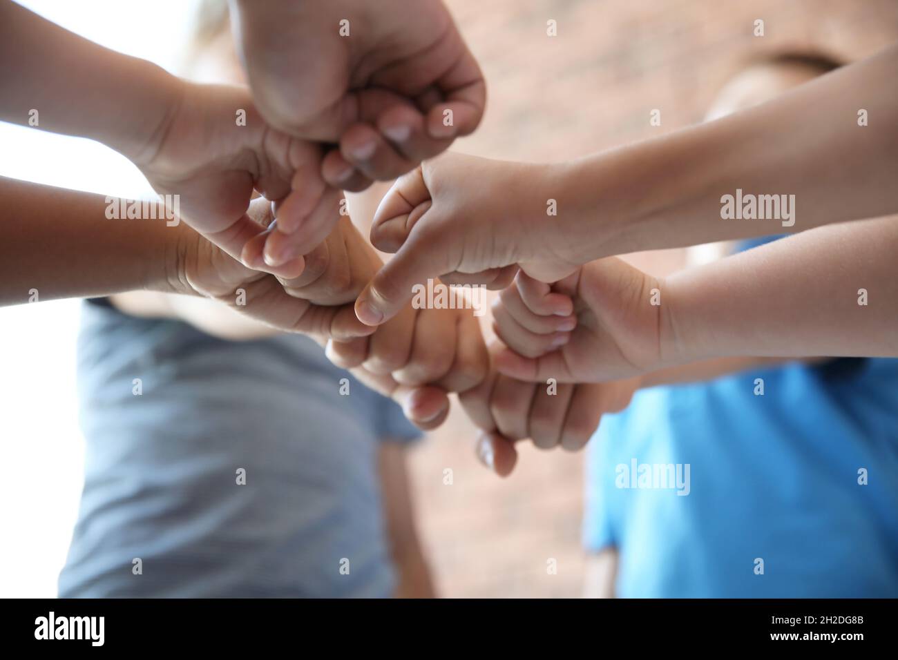 Little children putting their hands together on blurred background ...