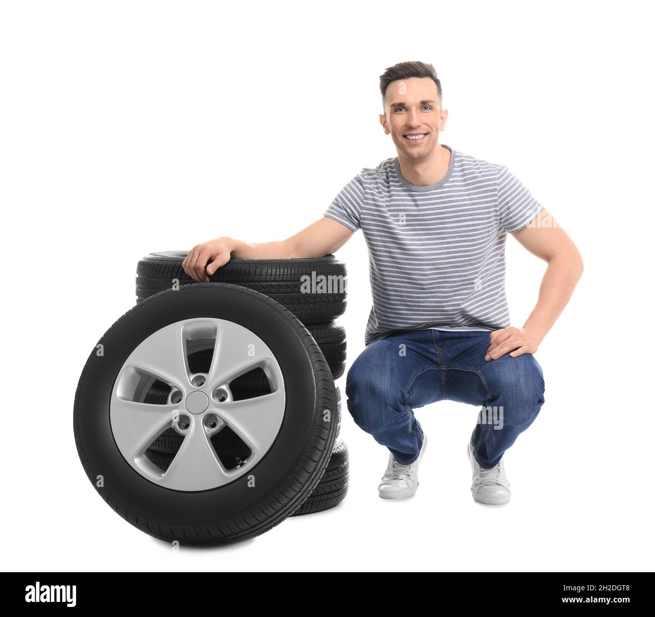 Young man with car tires on white background Stock Photo - Alamy