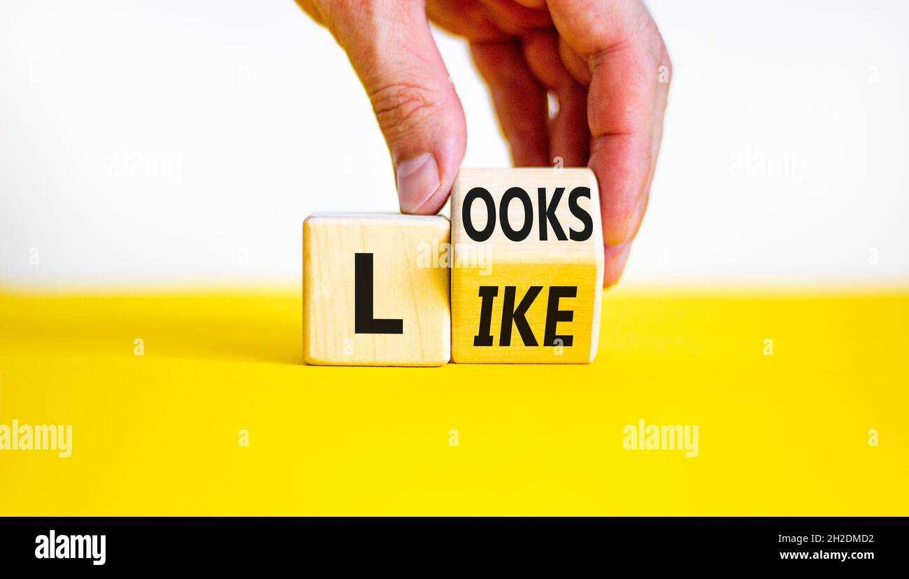 Looks like symbol. Businessman turns a wooden cube with words 'Looks ...