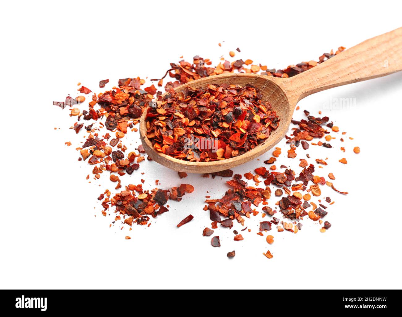 Wooden spoon and chili pepper flakes on white background Stock Photo ...