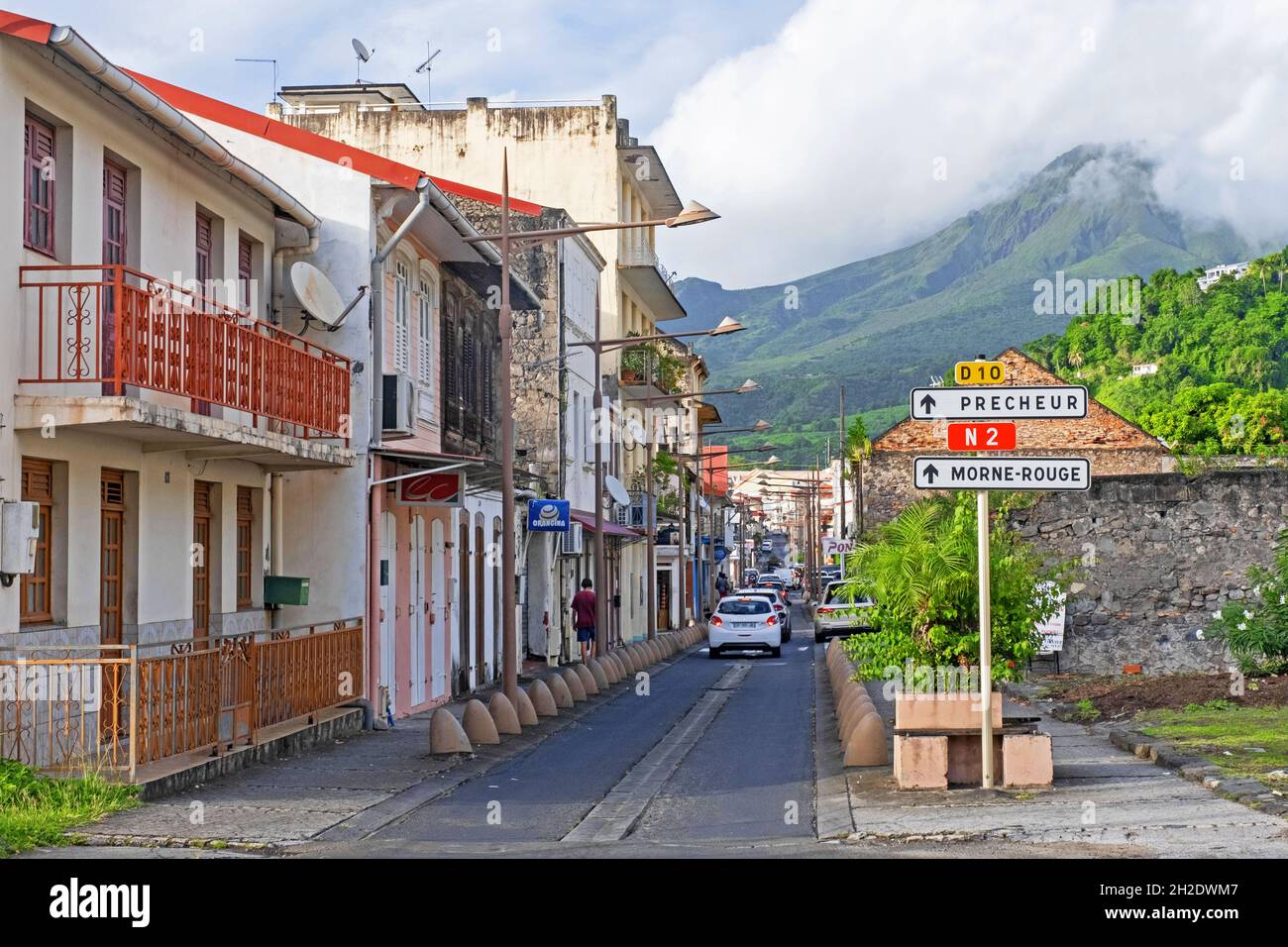 Street in the town Saint-Pierre and active volcano Mount Pelée on the ...
