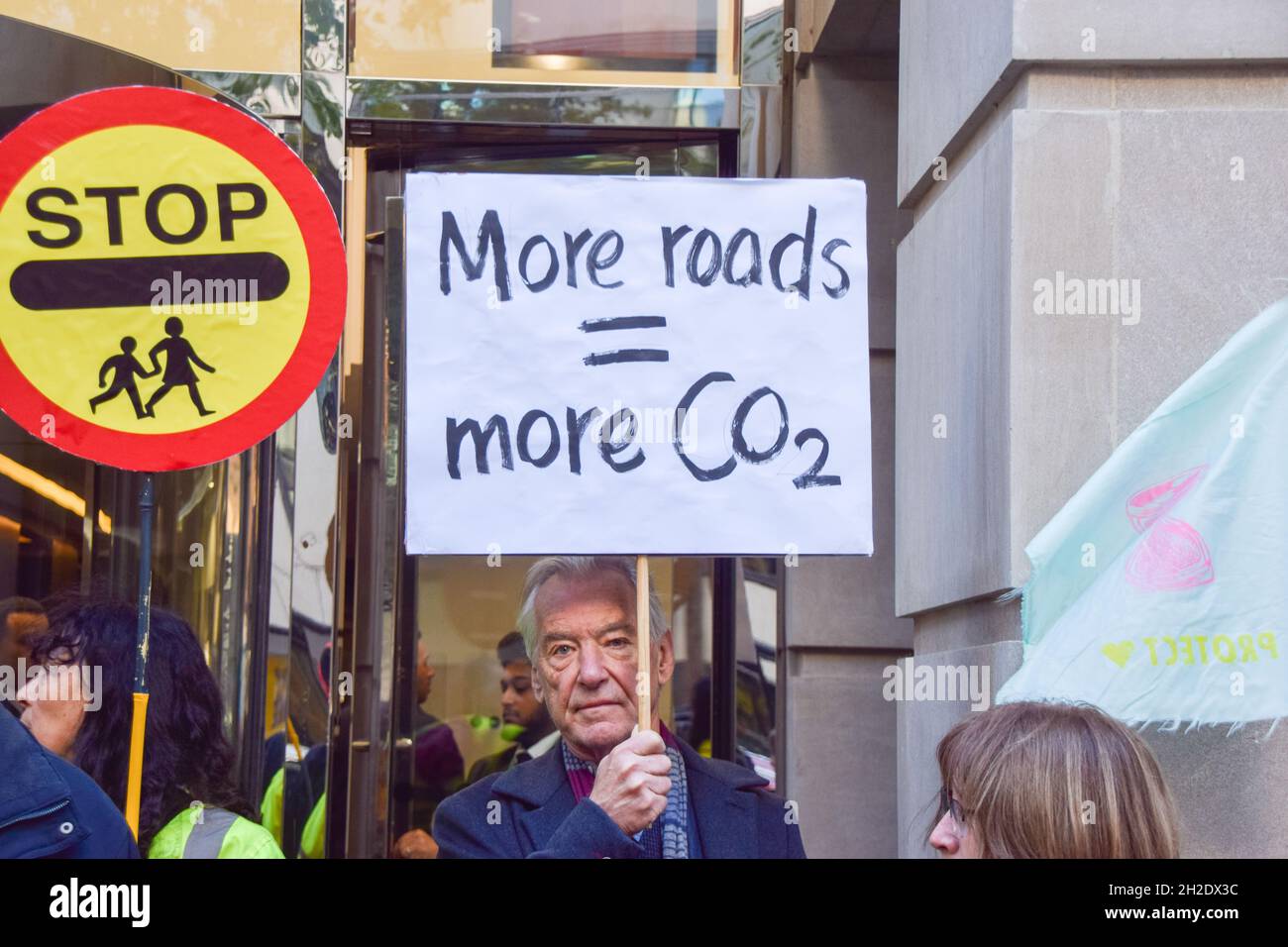 A protester holds a 'More roads = more CO2' placard during the ...