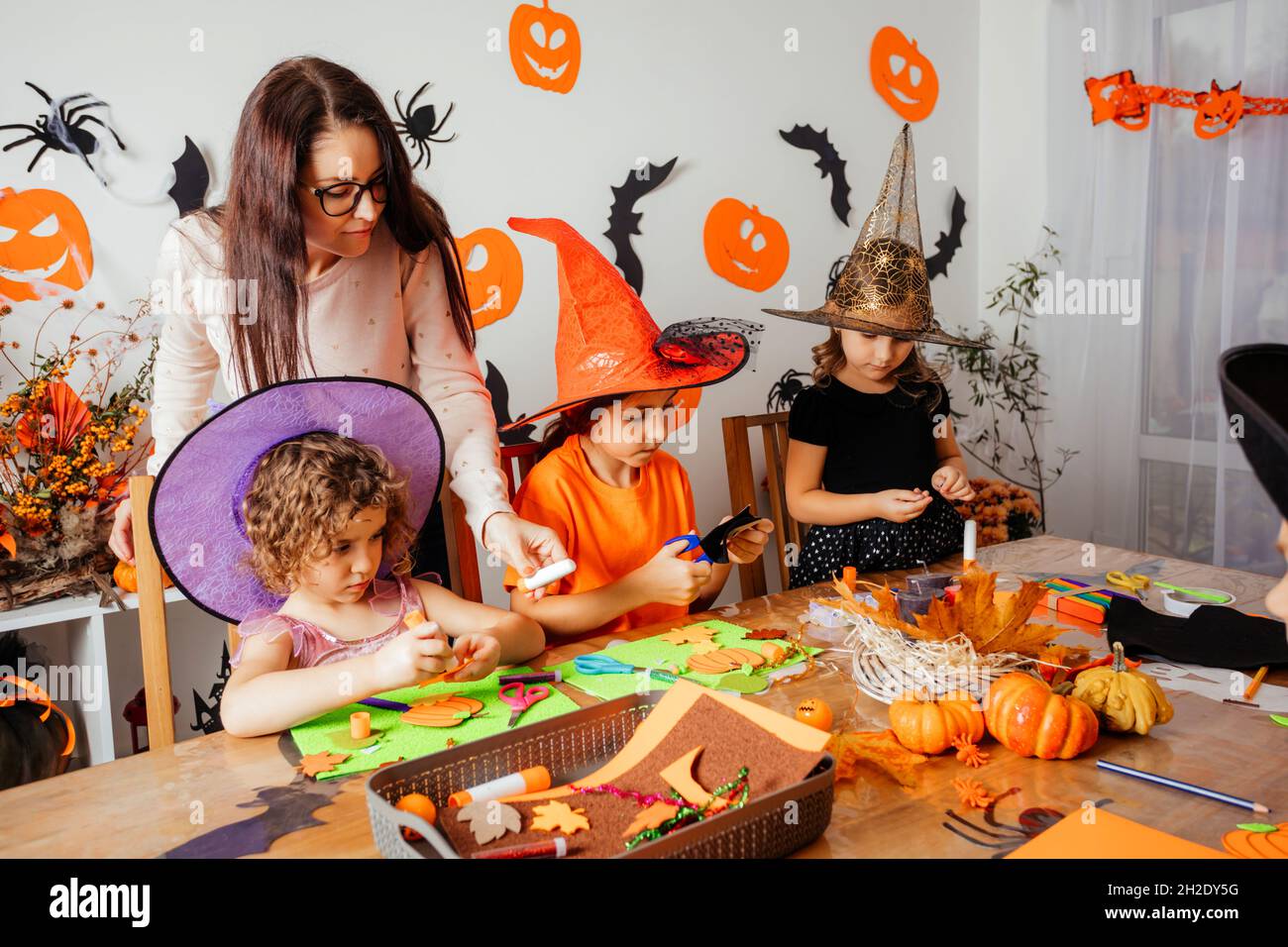 Teacher helping creative children to make paper bookmarks Stock Photo ...