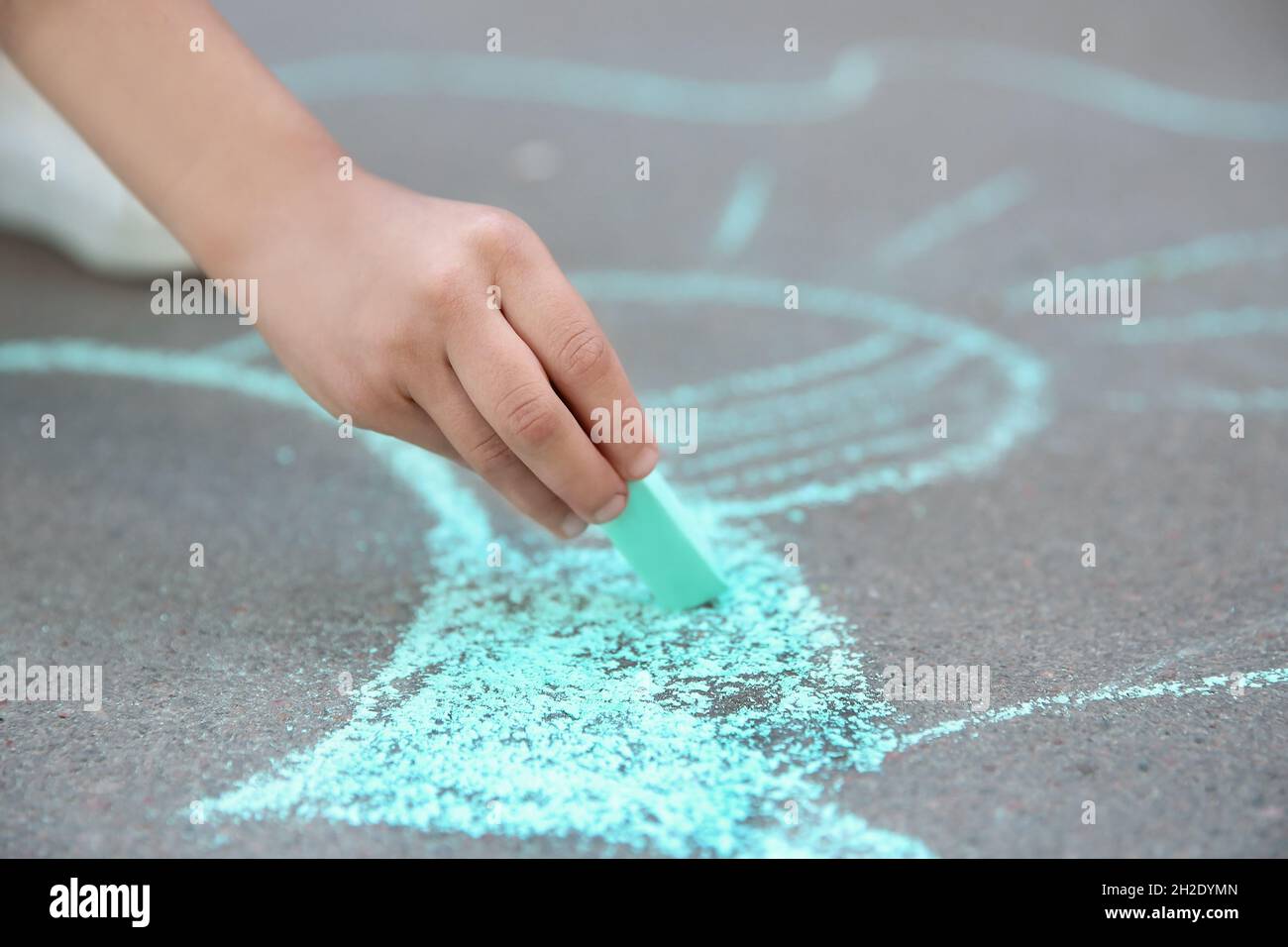 Little child drawing with chalk on asphalt, closeup Stock Photo - Alamy