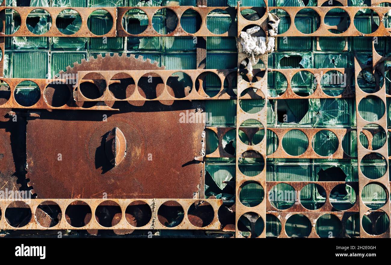 Wall of an old industrial building with broken glass panels and rusty ...