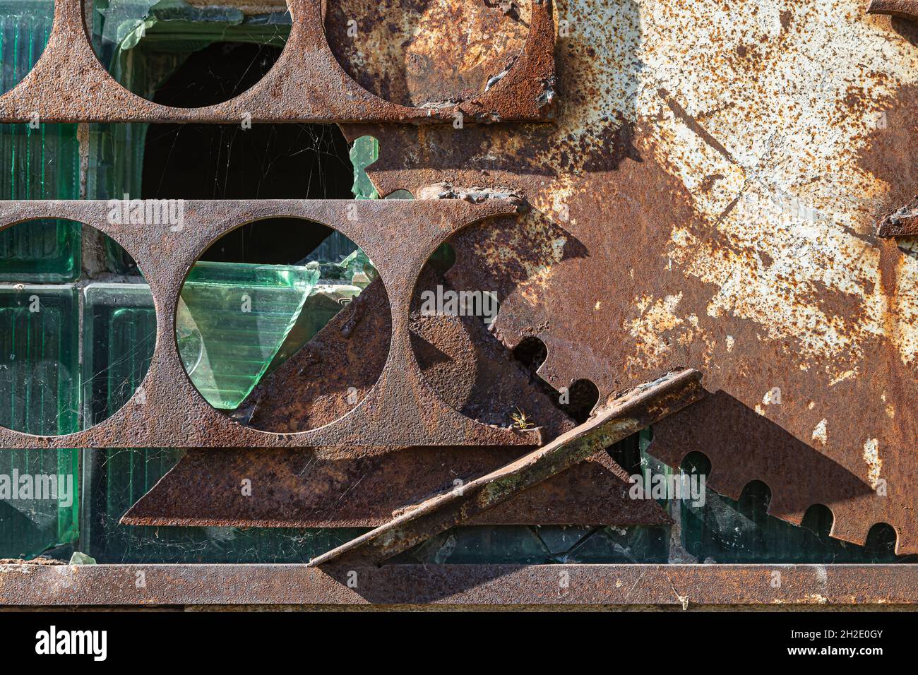 Wall of an old industrial building with broken glass panels and rusty ...