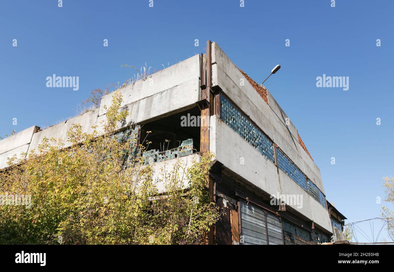 Wall of an old industrial building with broken glass panels and rusty ...