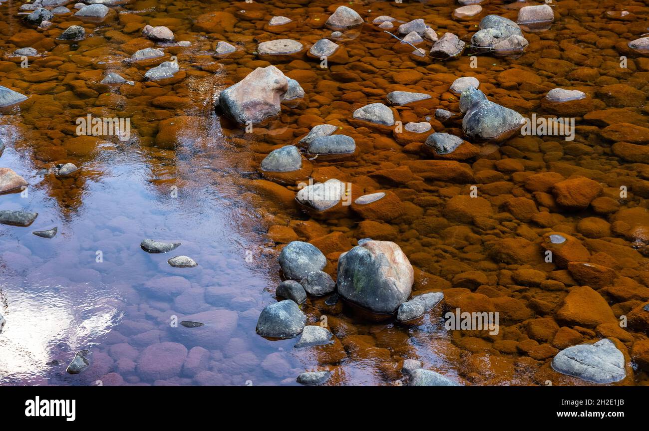 Water running down the river around rocks Stock Photo - Alamy