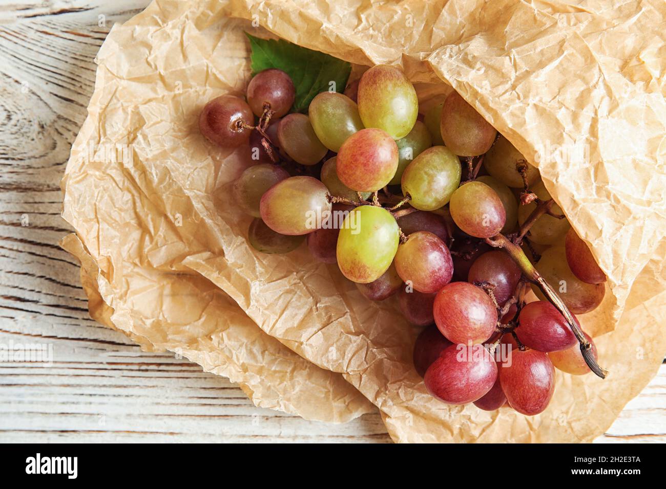 Fresh ripe juicy grapes and paper on table, top view Stock Photo - Alamy
