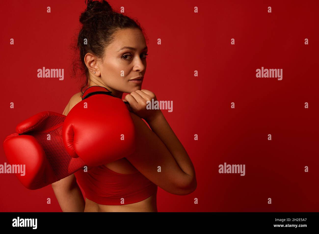 Attractive wavy haired pretty female athlete, woman boxer fighter poses ...