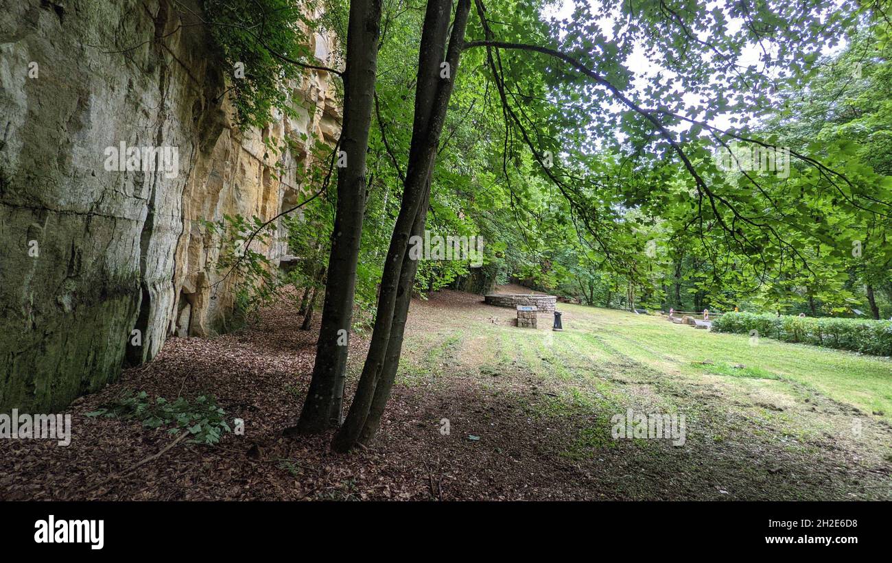 Beautiful view of a grassy field surrounded by rocky walls in the park ...