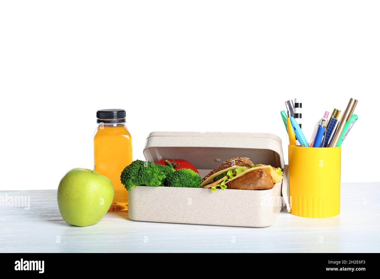 Healthy food and stationery on table against white background. School ...