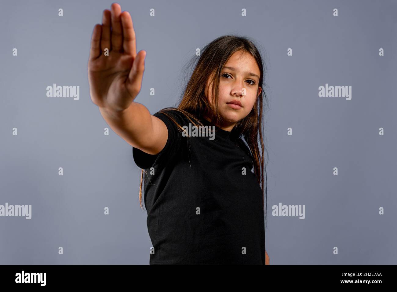 Close-up of emotional portrait of serious beautiful girl showing stop ...