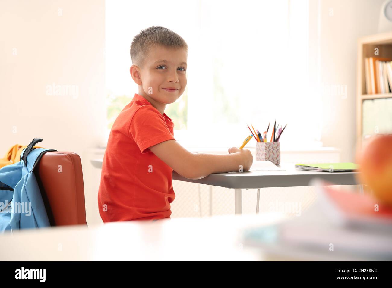 Cute little child sitting at desk in classroom. Elementary school Stock ...