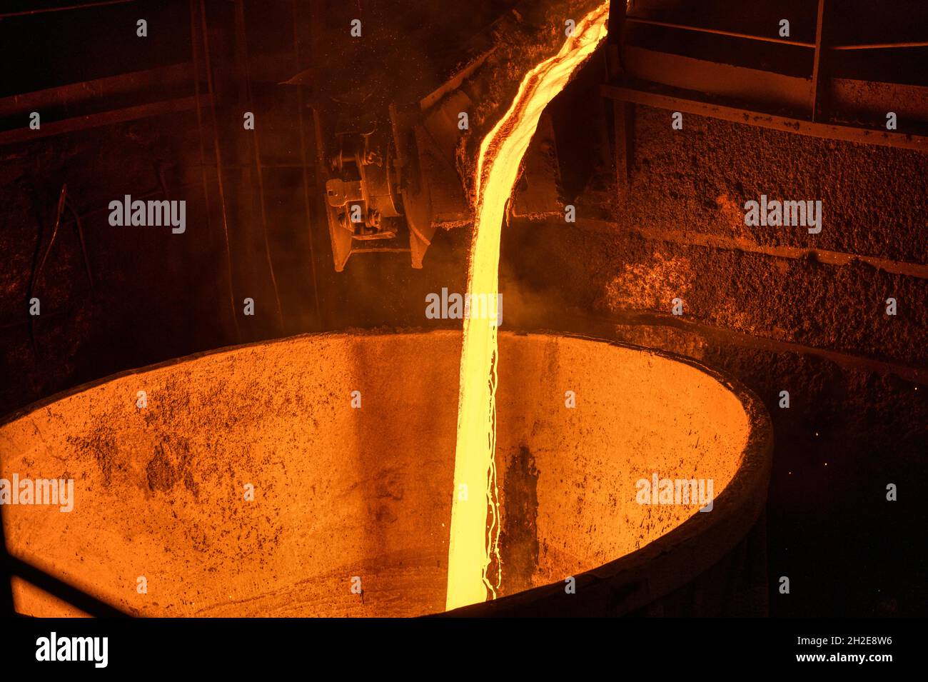 A stream of molten slag is poured into a metallurgical ladle Stock ...