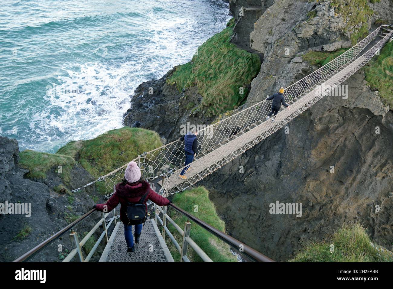 Tourists cross Carrick-a-rede Rope Bridge, popular tourist attraction ...