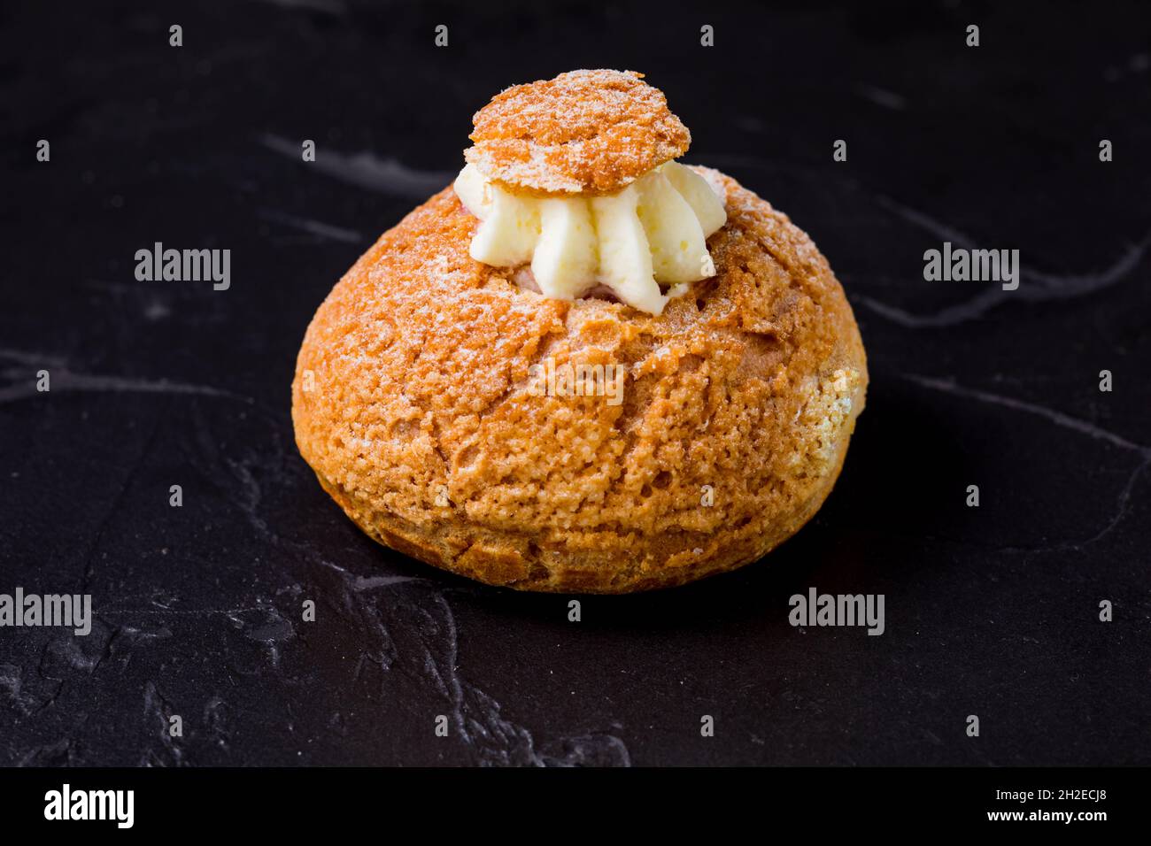 One choux cake with whipped cream on the black Stock Photo - Alamy