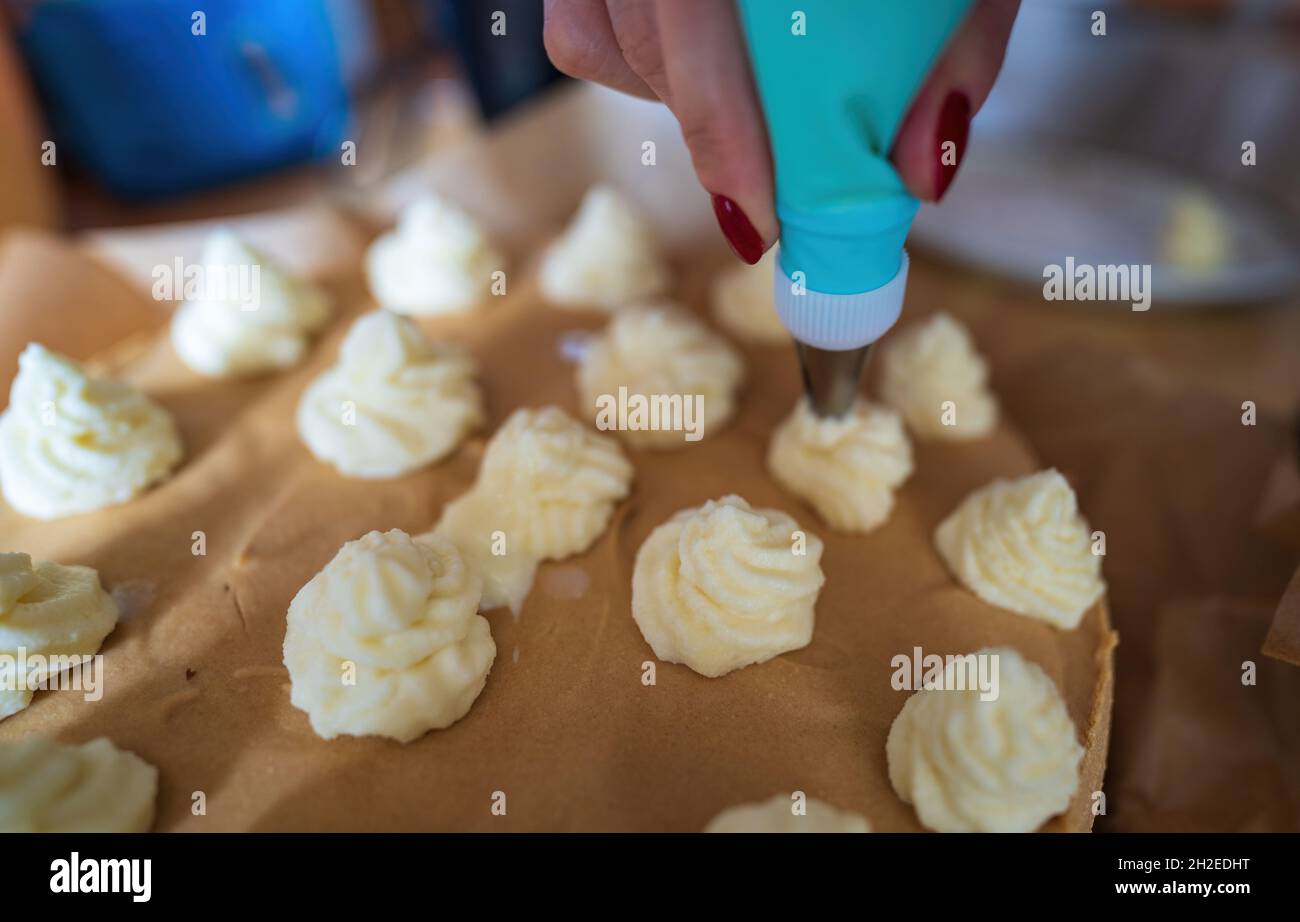 Parchment or paper Piping Bag Icing Cone used by a female hand to ...