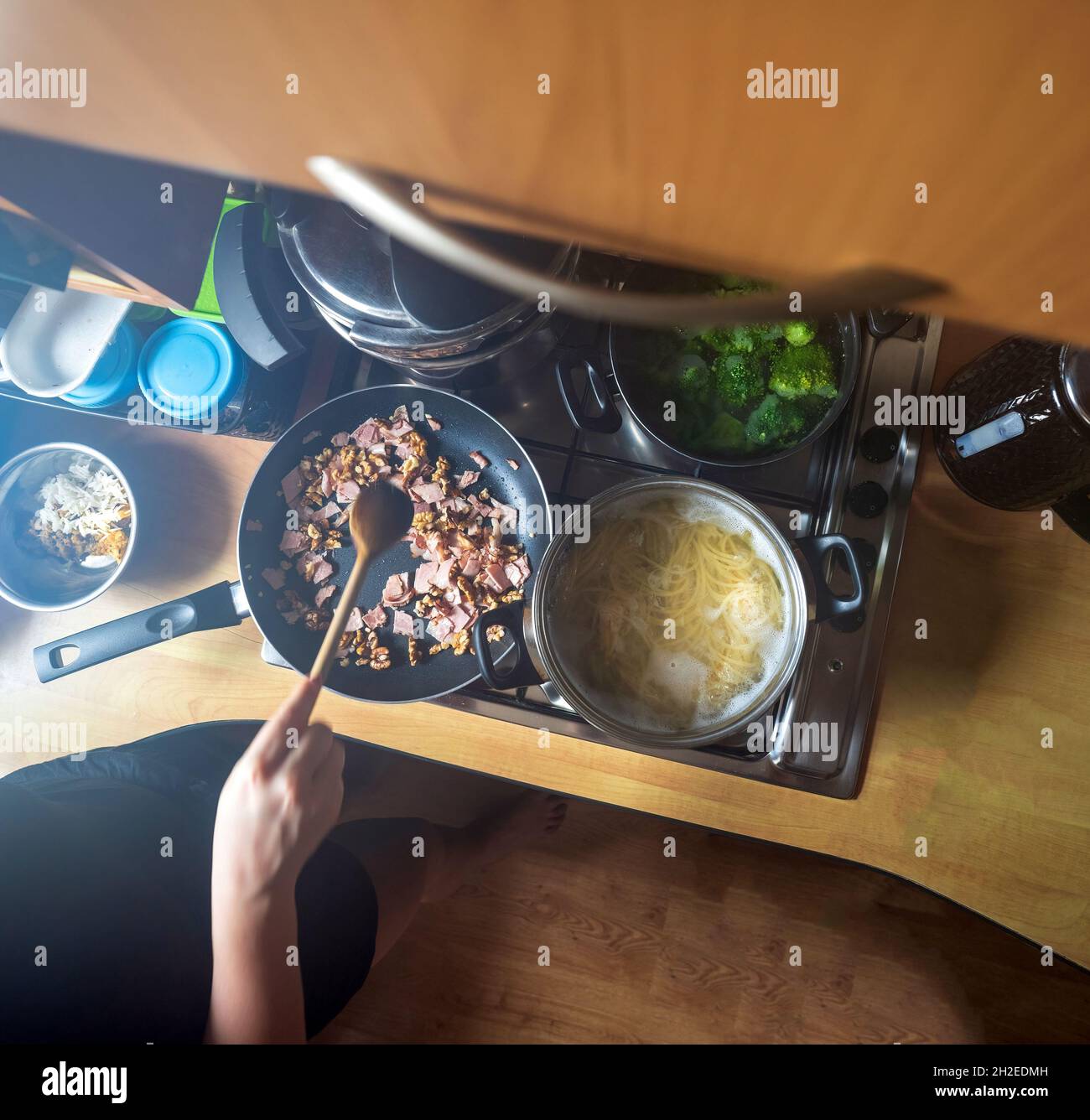 Spaghetti being boiled in boiling water along with walnut, ham and ...