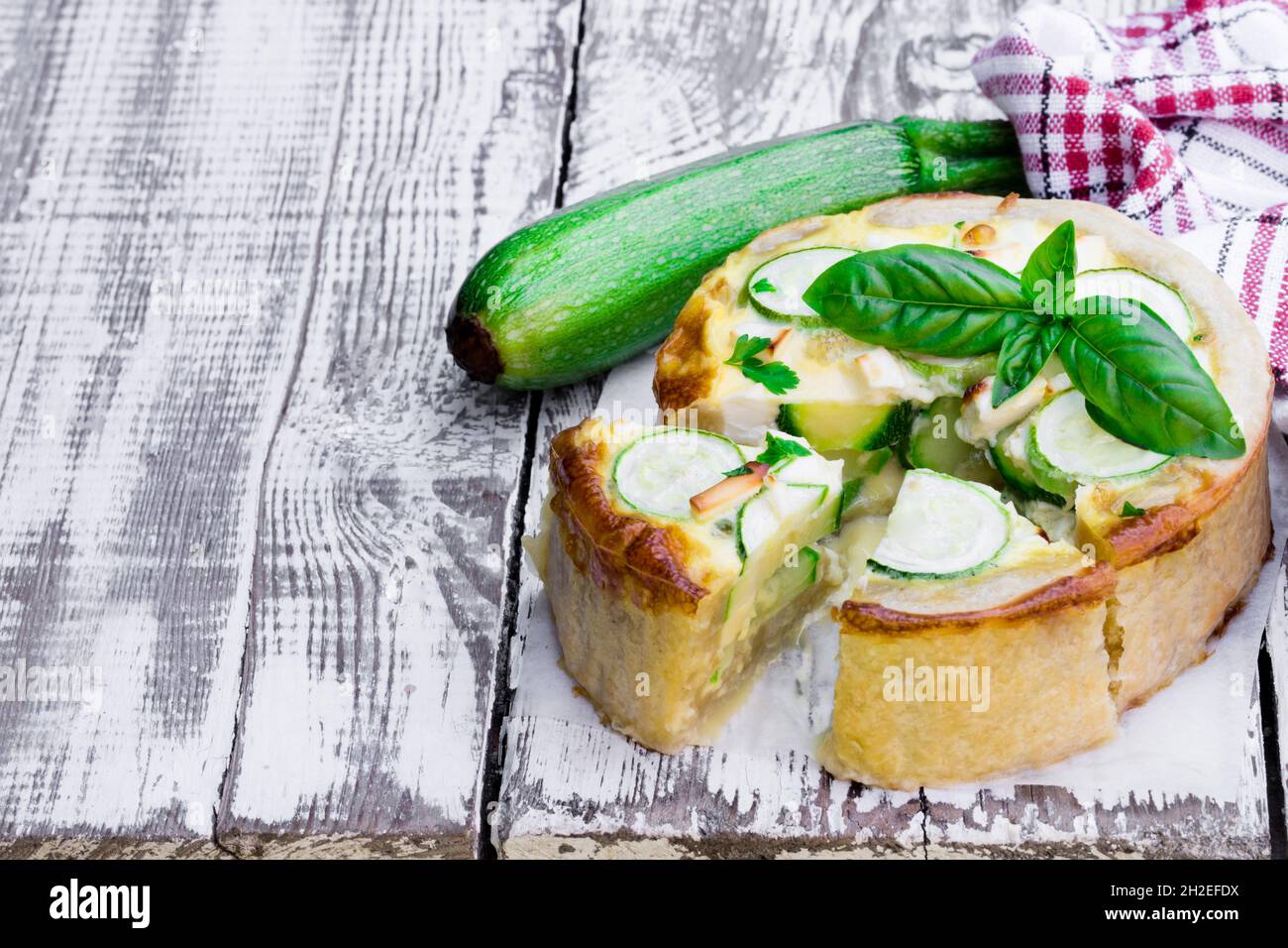 Courgette and feta cheese quiche on white wooden table Stock Photo - Alamy