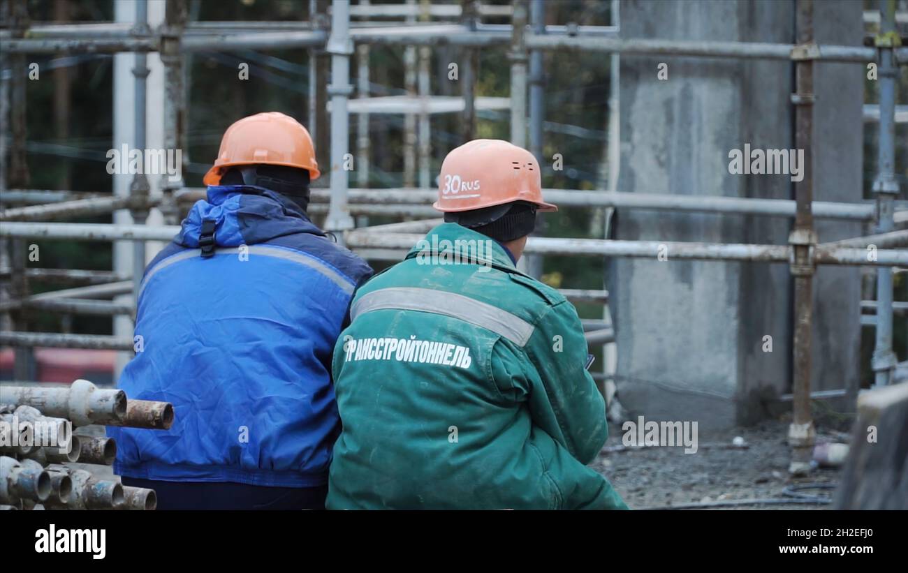 Rear view of two engineer builders at construction site directing. Clip ...