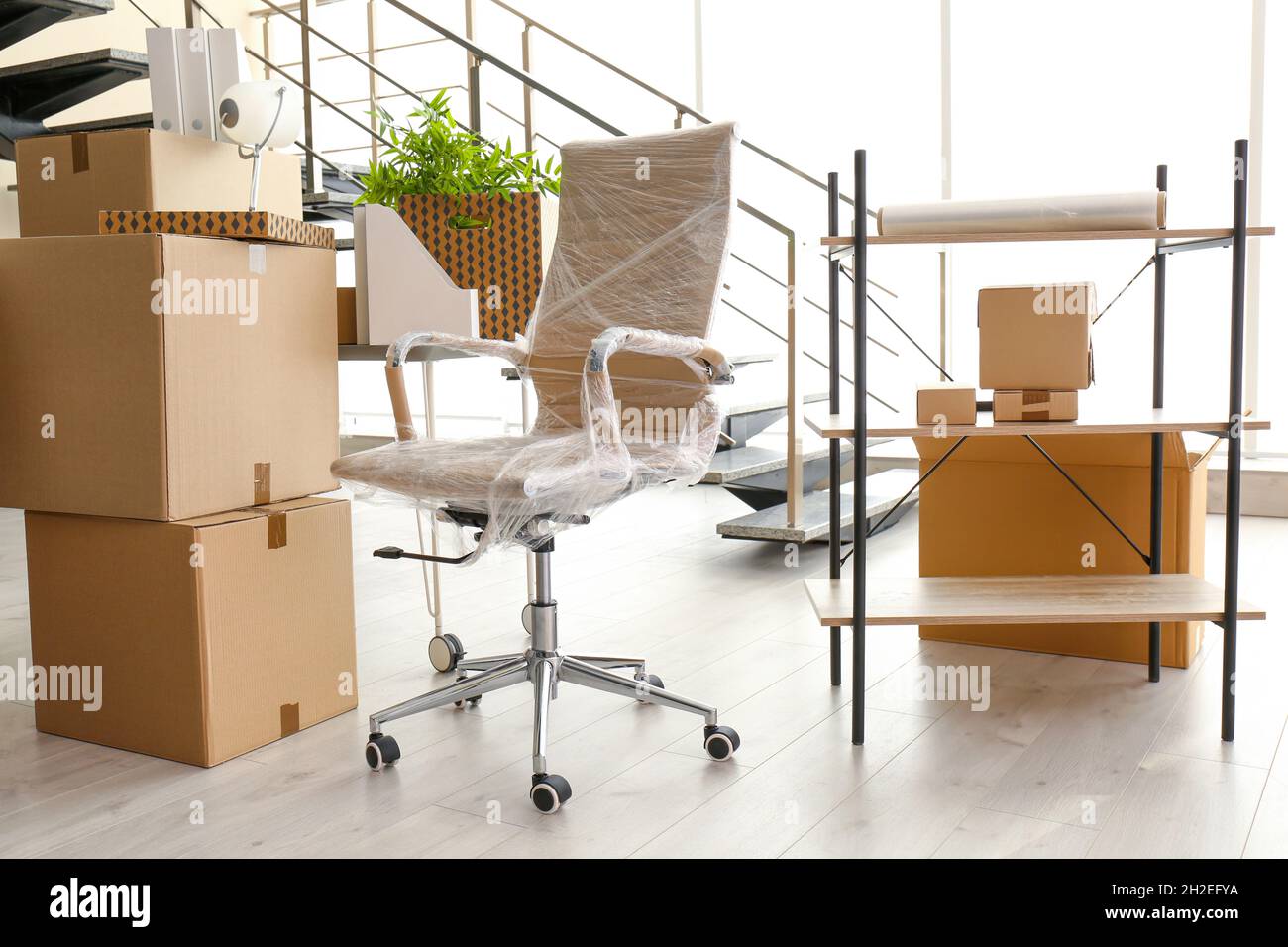 Moving boxes and furniture in new office Stock Photo - Alamy