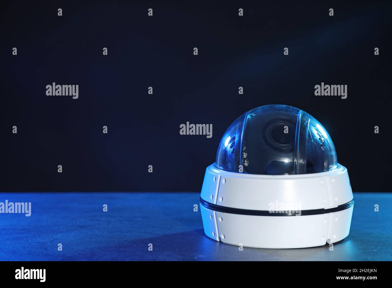 Modern security CCTV camera on table against dark background Stock ...