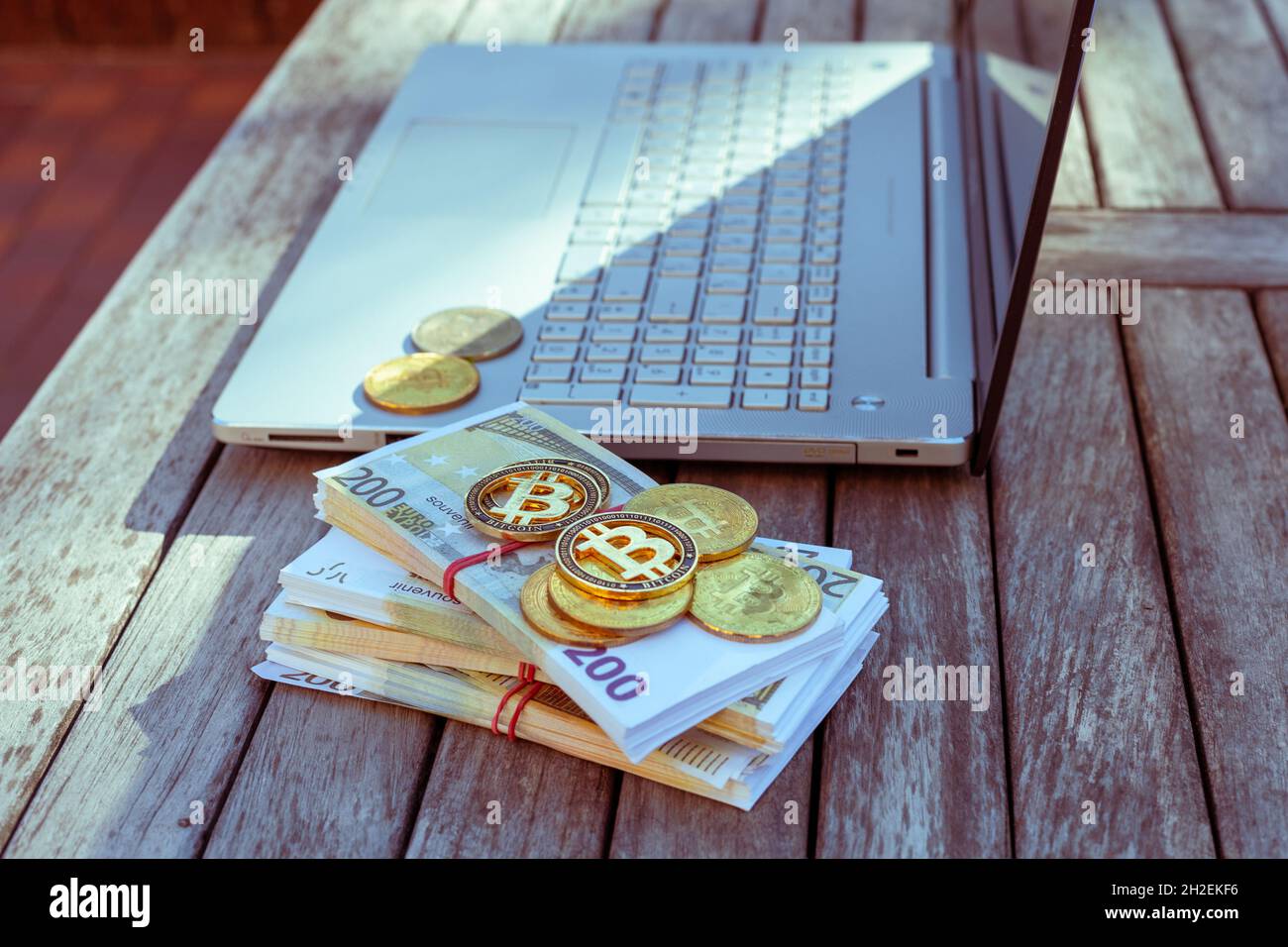 There are bitcoins money and a laptop on the table. Bitcoin coins lie ...