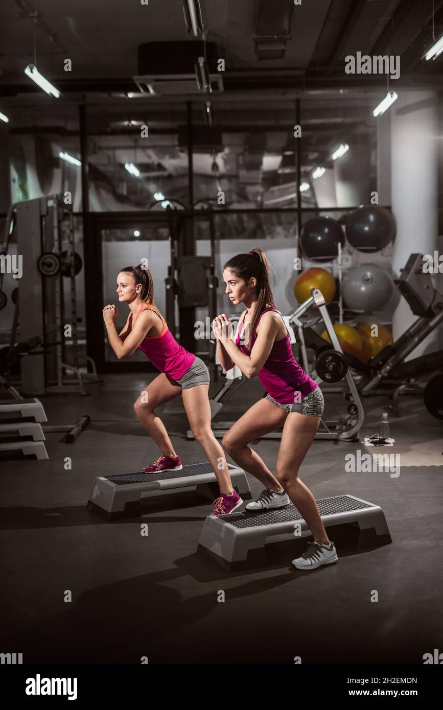 Two sporty women stepping up on stepper in gym. Healthy lifestyle ...