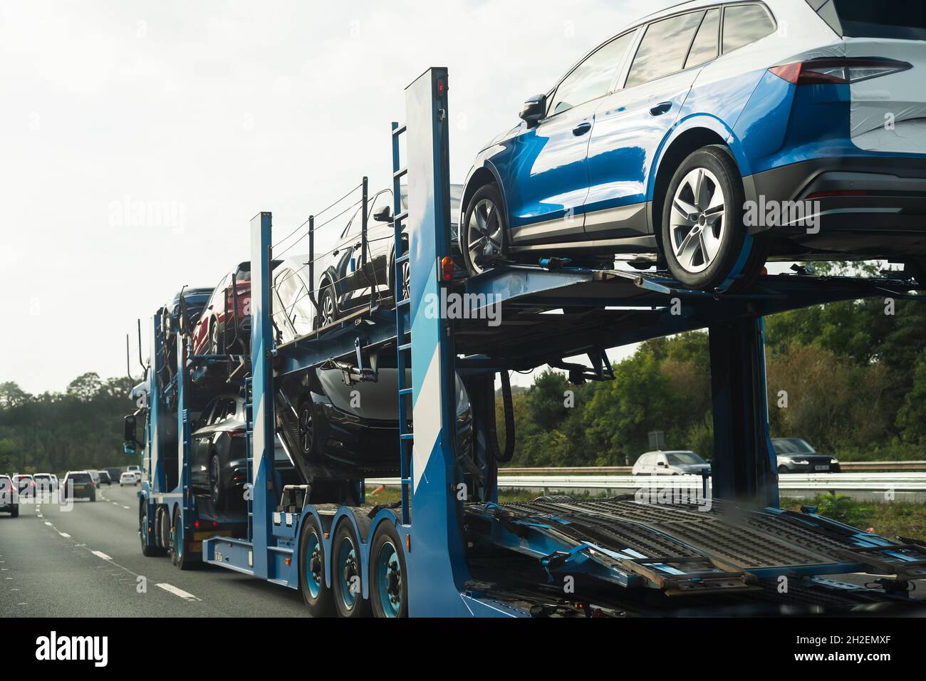 A car transporter loaded with vehicles moving at speed on a motorway ...
