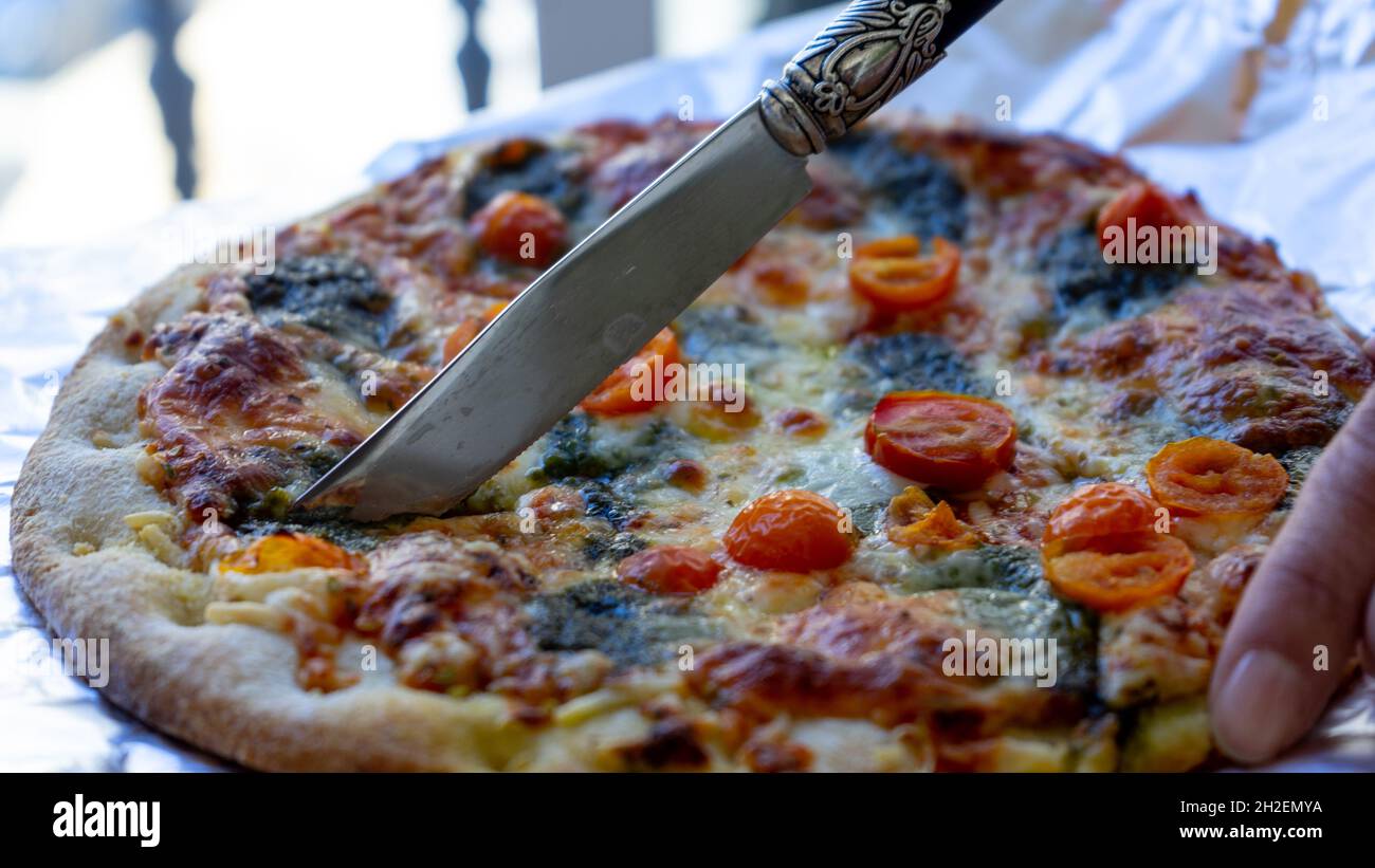 cutting a pizza with a knife Stock Photo - Alamy