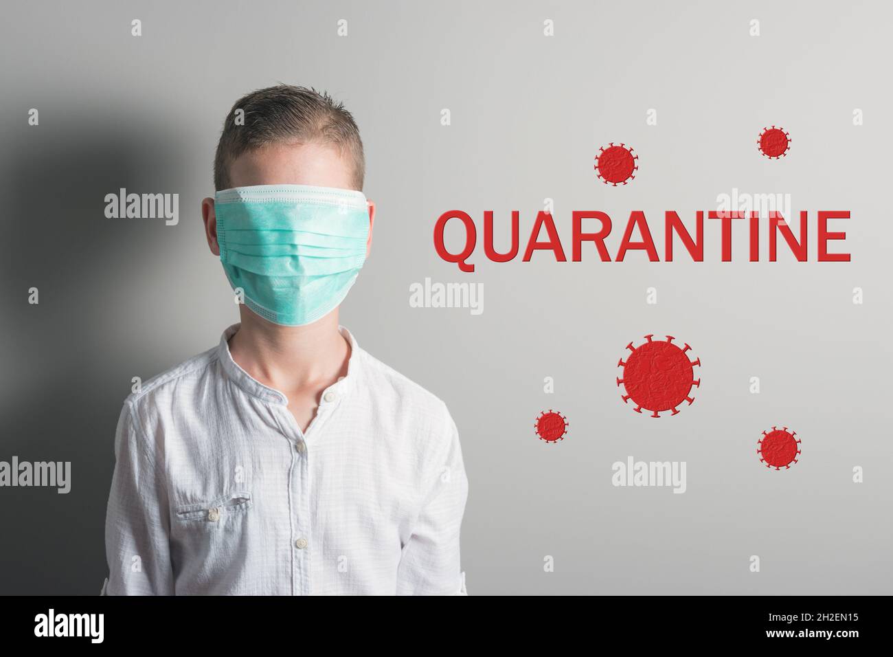 Boy in a medical mask on his face with red inscription QUARANTINE on ...
