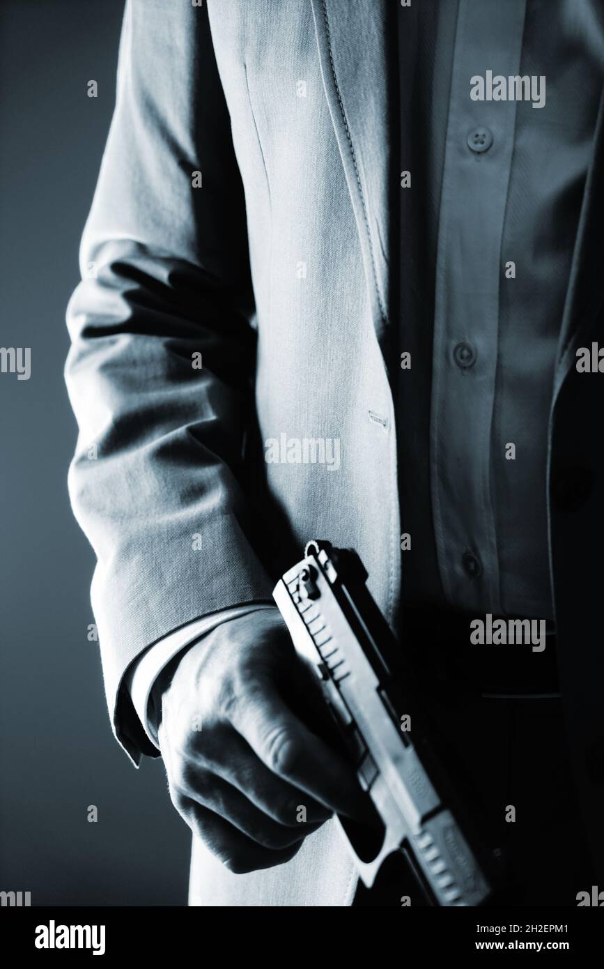 Retro secret agent with pistol revolver gun in hand in vintage crime ...