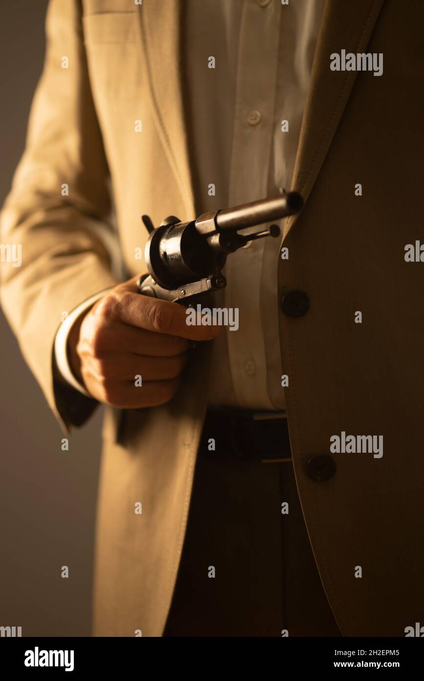 Male detective spy killer holding pistol gun in dramatic novel book ...