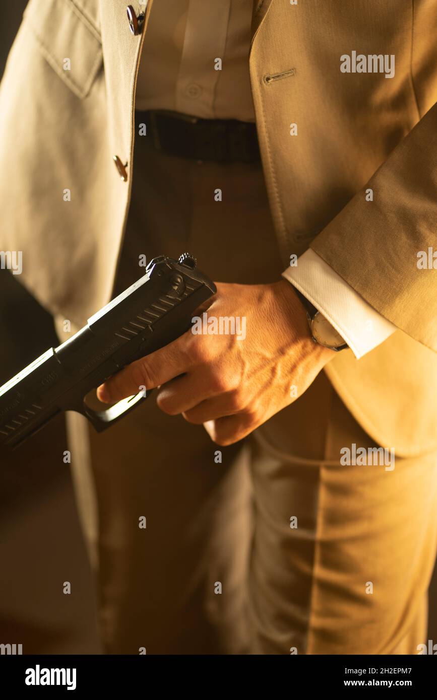 Male detective spy killer holding pistol gun in dramatic novel book ...