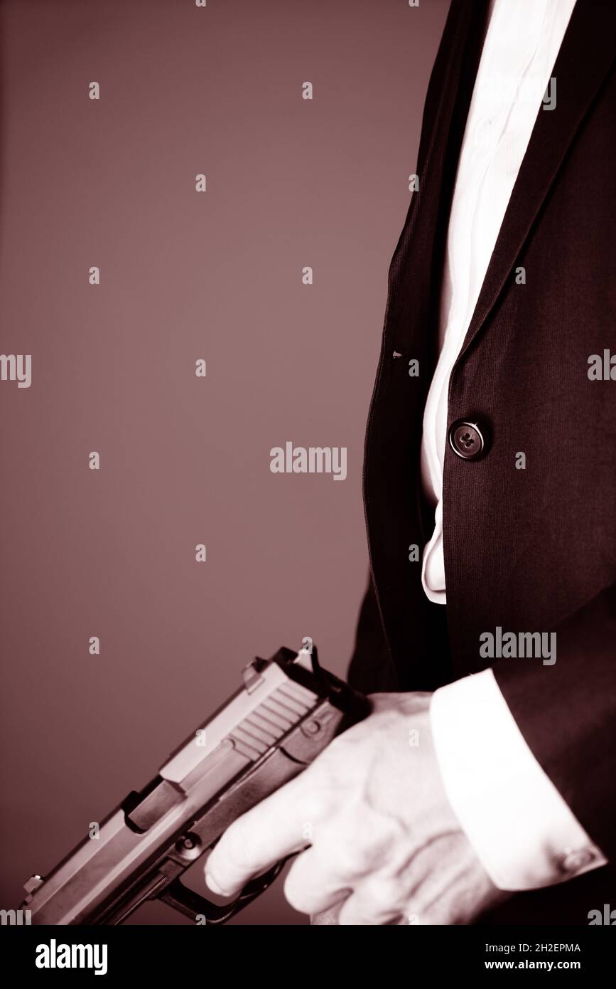 Retro secret agent with pistol revolver gun in hand in vintage crime ...