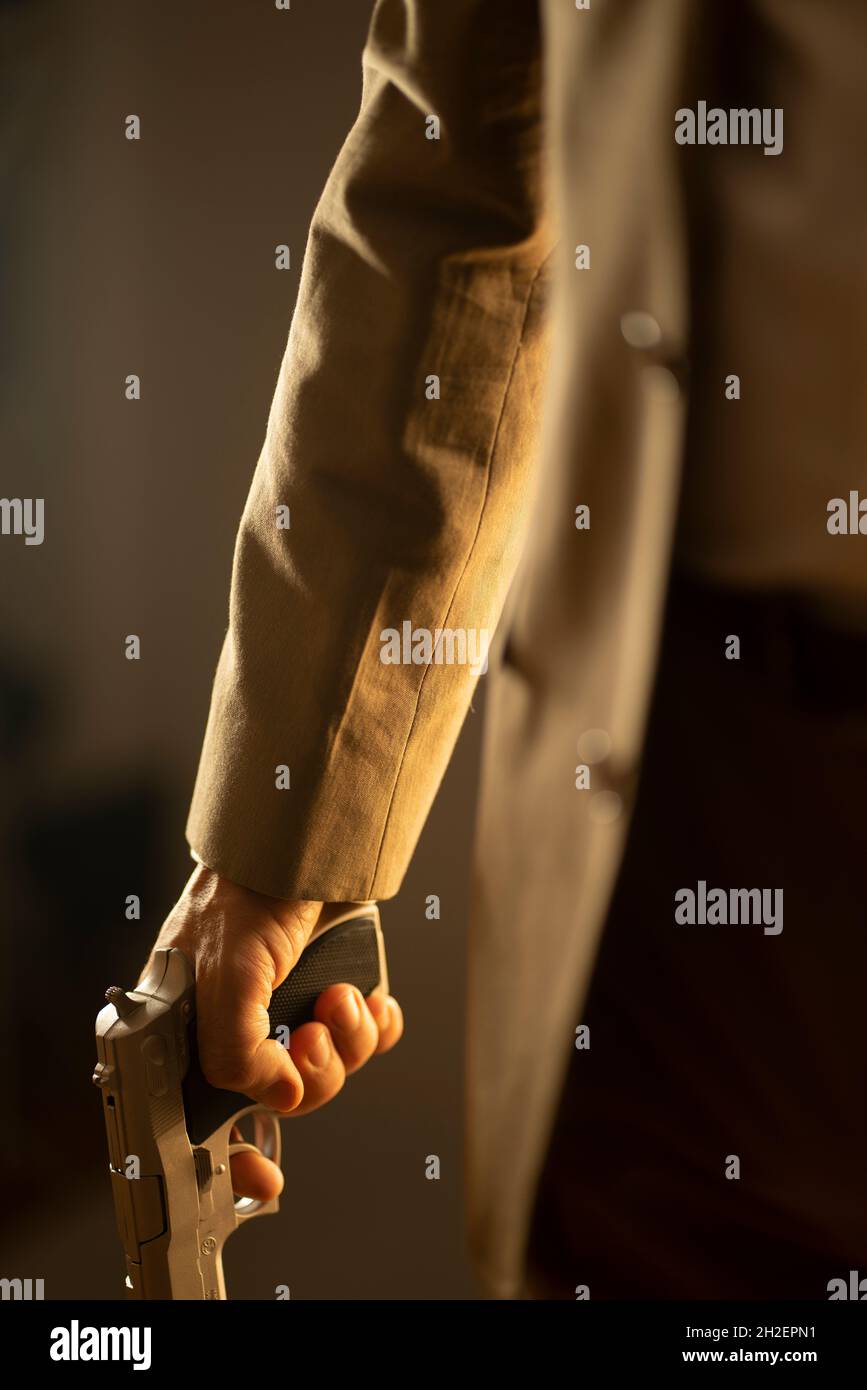 Male detective spy killer holding pistol gun in dramatic novel book ...