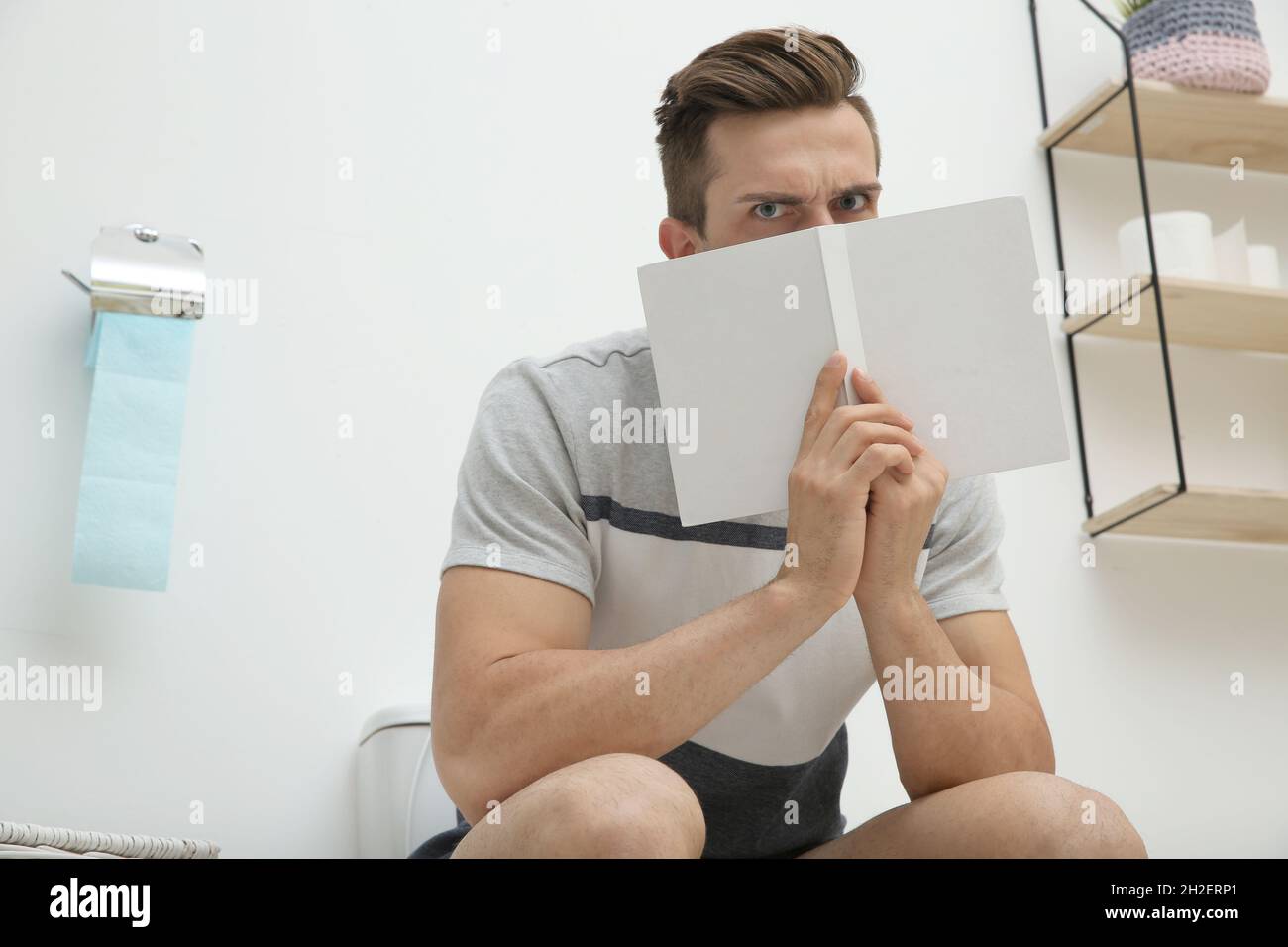 Man on toilet reading book hi-res stock photography and images - Alamy
