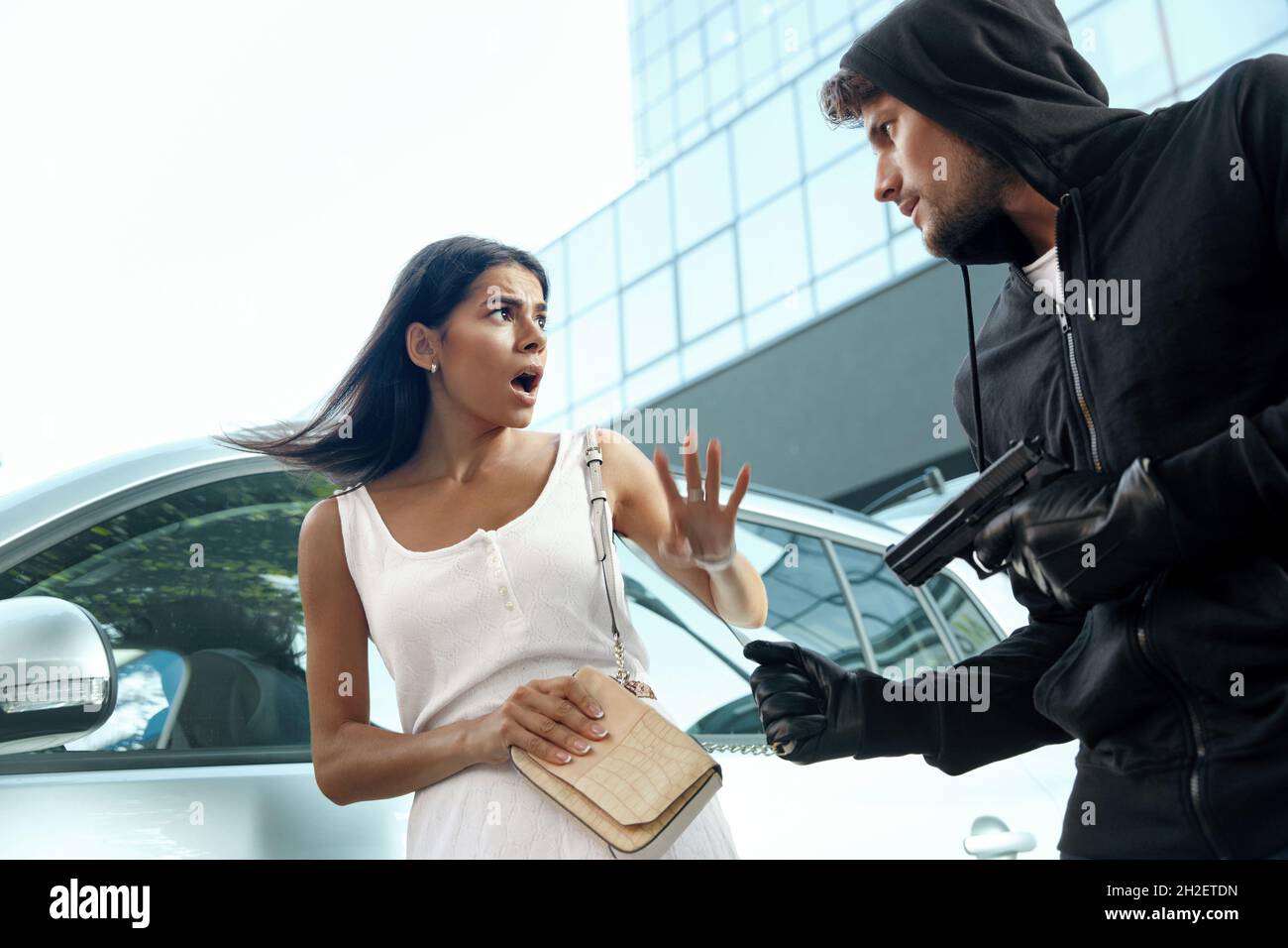 Angry robber want to steal handbag of frightened girl. Male bandit wear ...