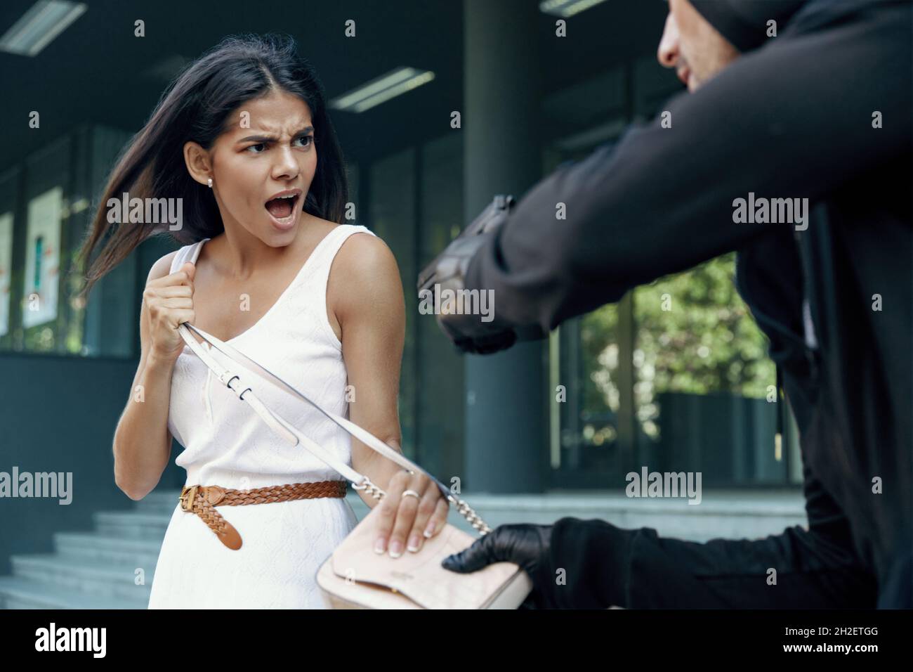Robber want to steal handbag of angry girl. Male bandit wear black ...
