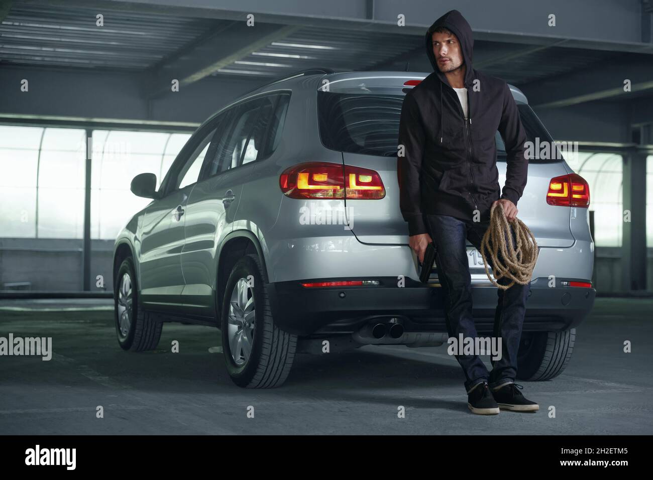 Focused caucasian robber standing near private automobile. Male bearded ...