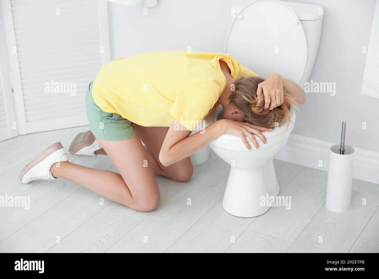 Young woman vomiting in toilet bowl at home Stock Photo - Alamy