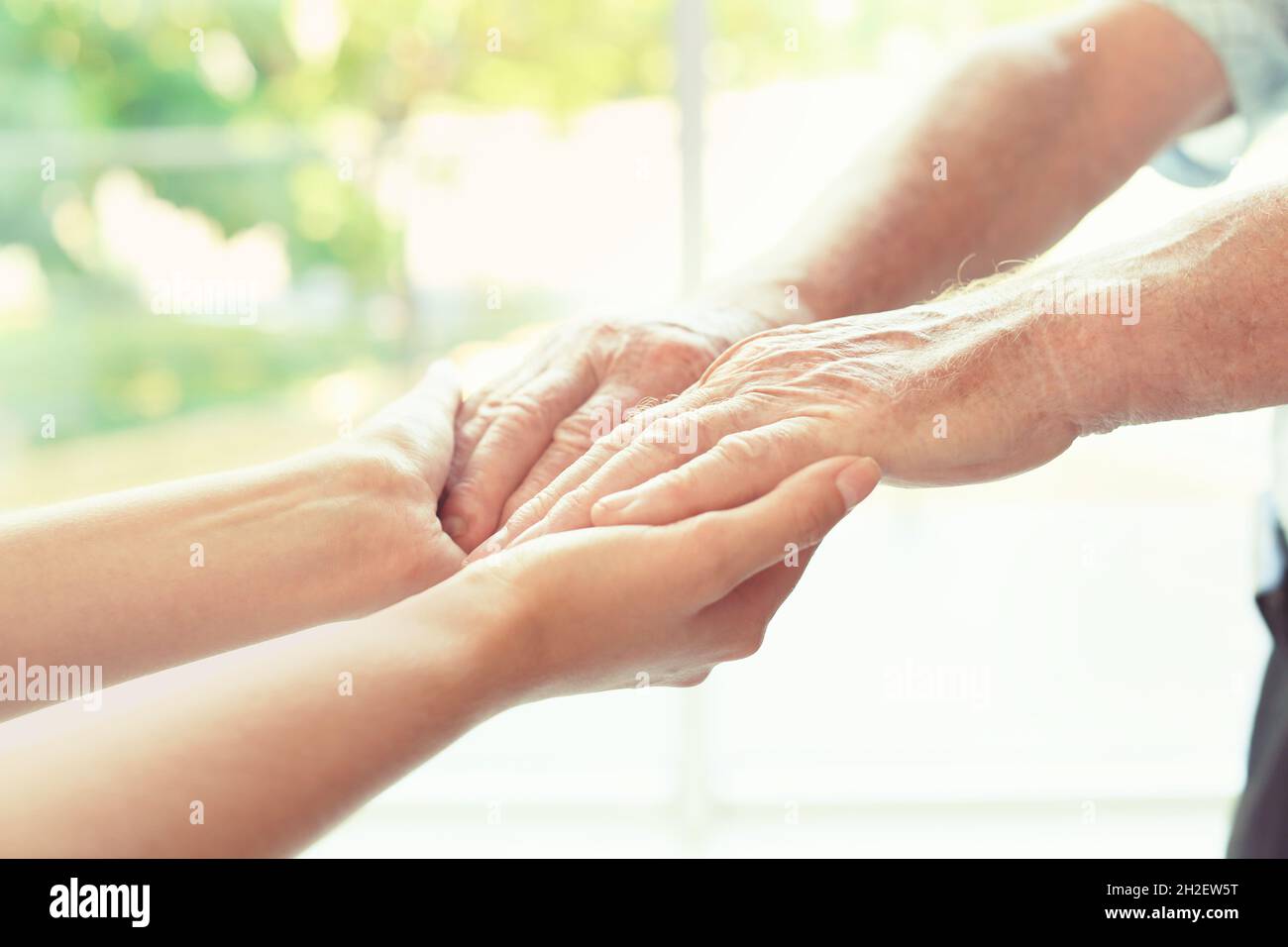 Helping hands on blurred background, closeup. Elderly care concept ...