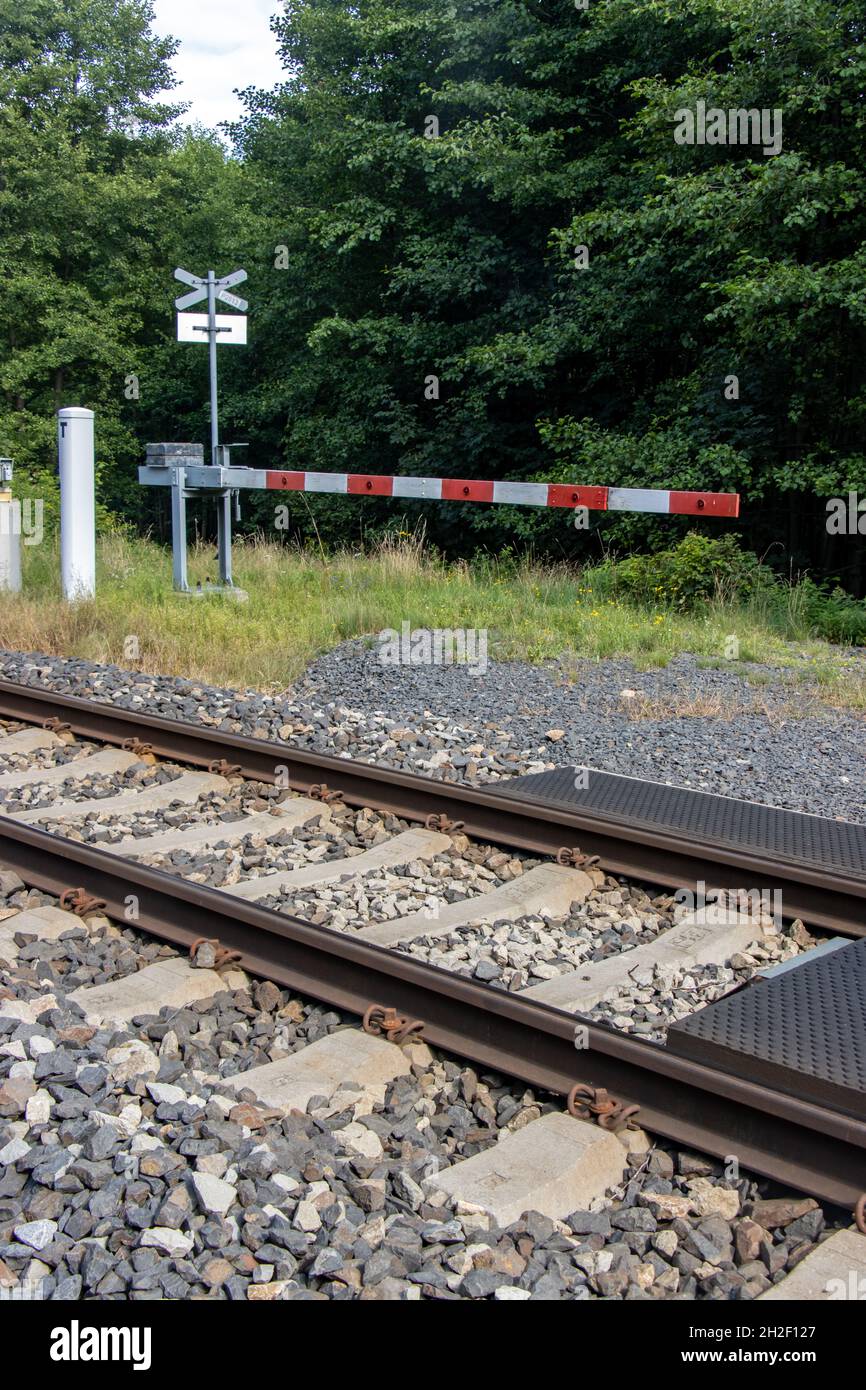 Forest footpath closed by a barrier before entering the tracks Stock ...