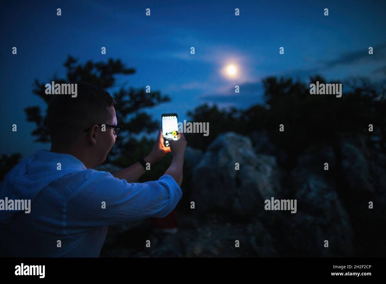 The concept of astrophotography a young man photographs the moon on his ...