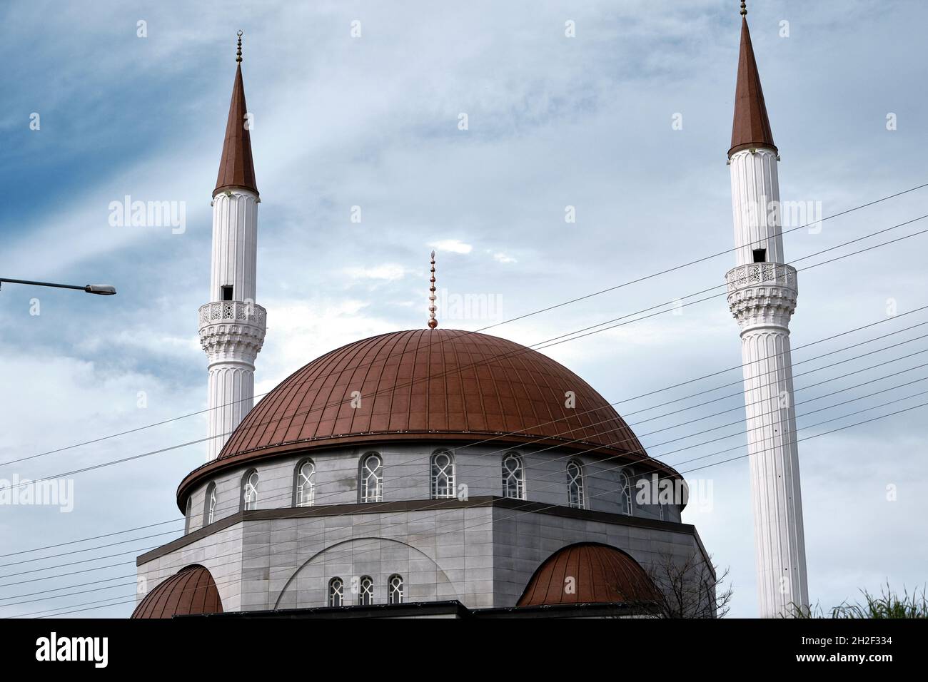 Two minarets and newly established mosque with its red color dome with ...