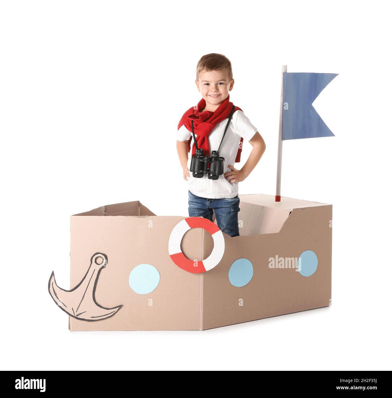 Cute little boy playing with cardboard ship on white background Stock ...